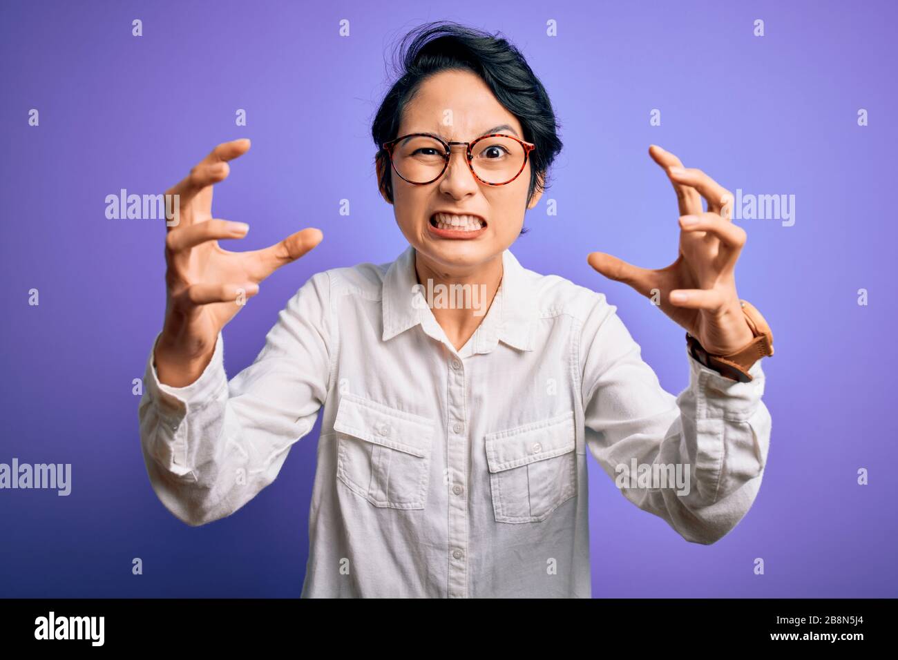 Young beautiful asian girl wearing casual shirt and glasses standing ...