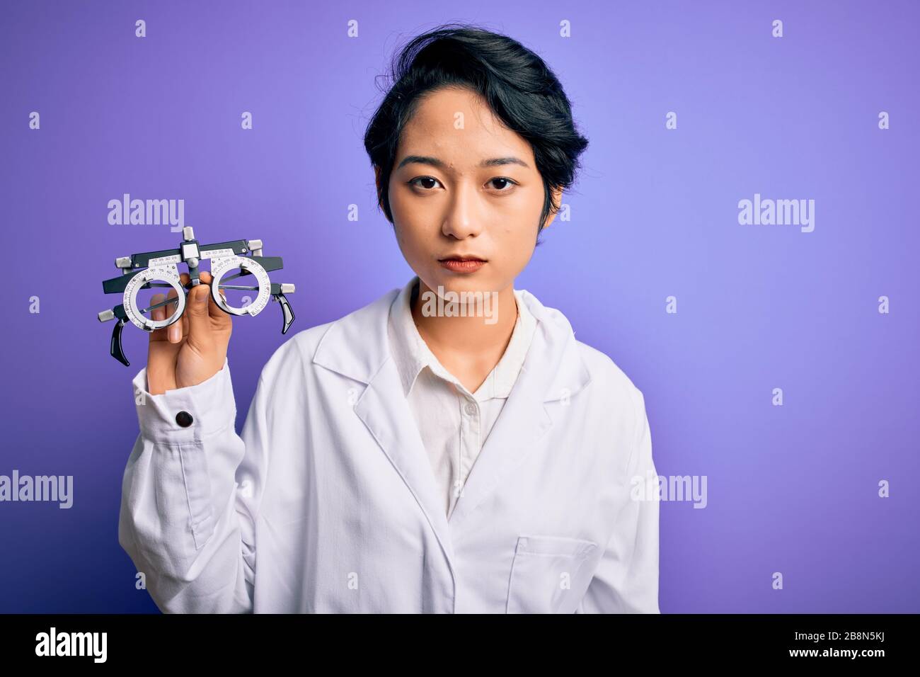 Beautiful asian optical girl wearing coat holding optometry glasses ...