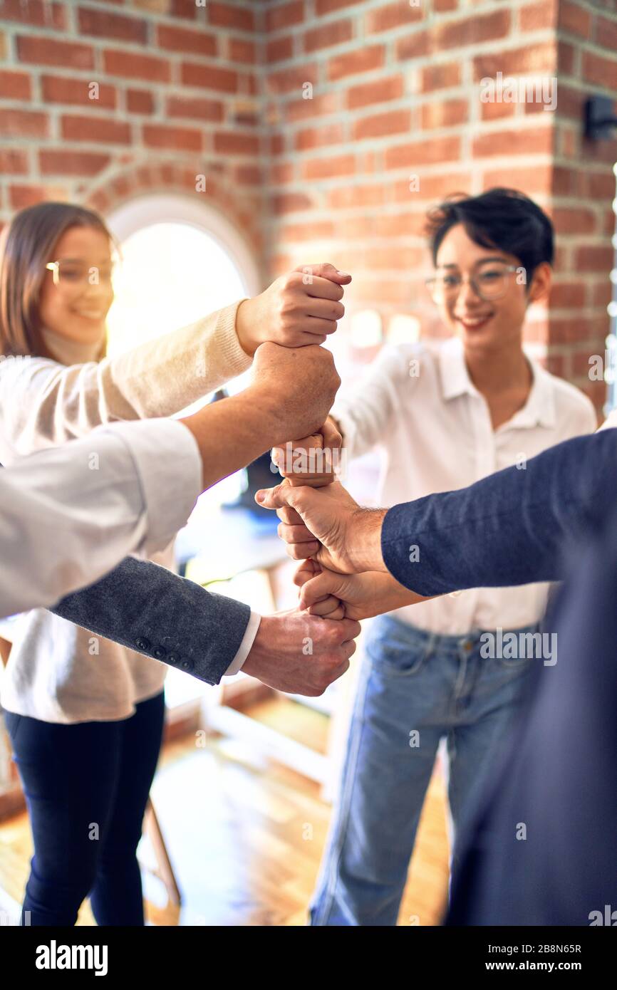 Group of business workers smiling happy. Standing bumping fists at the ...