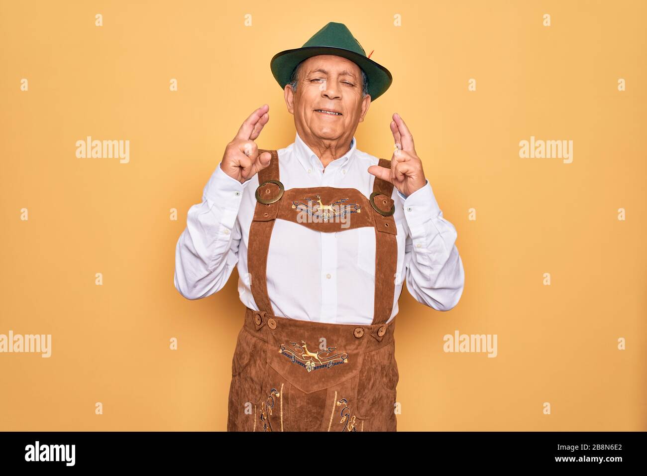 Senior grey-haired man wearing german traditional octoberfest suit over ...