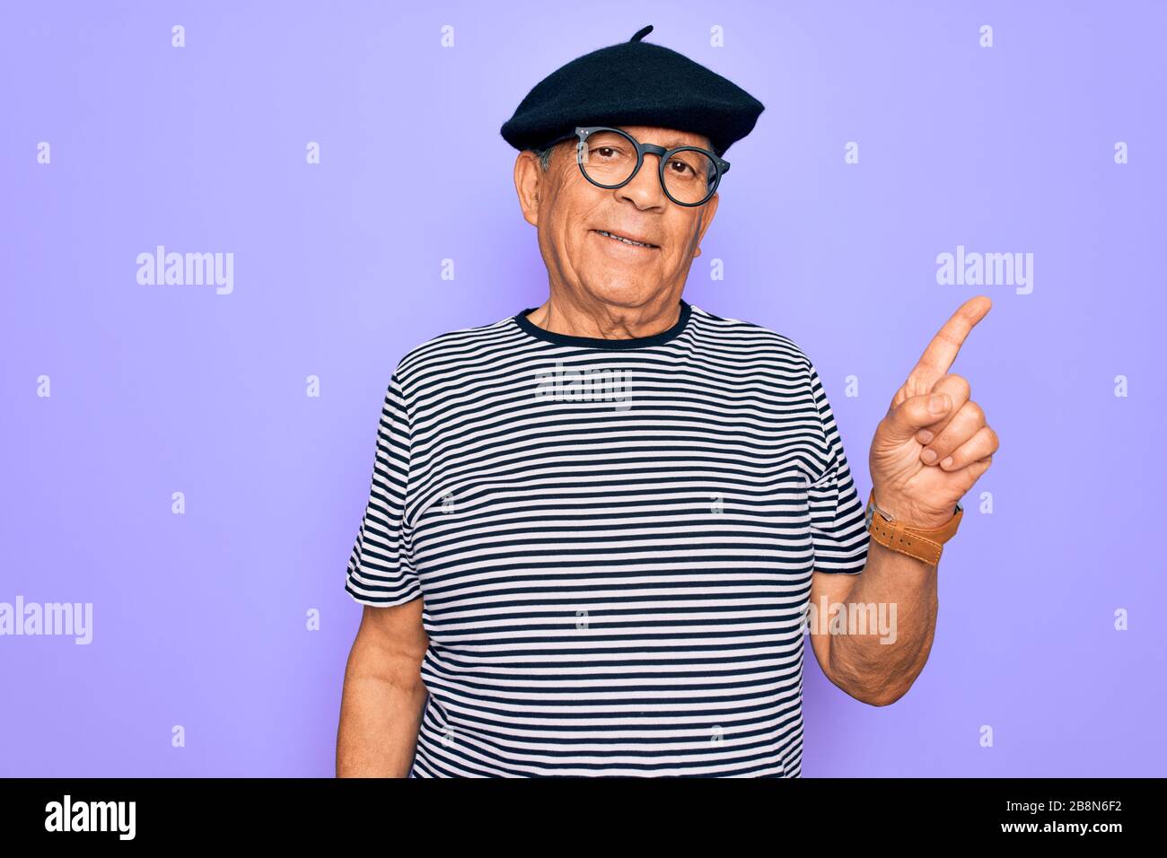 Senior handsome hoary man wearing french beret and glasses standing ...