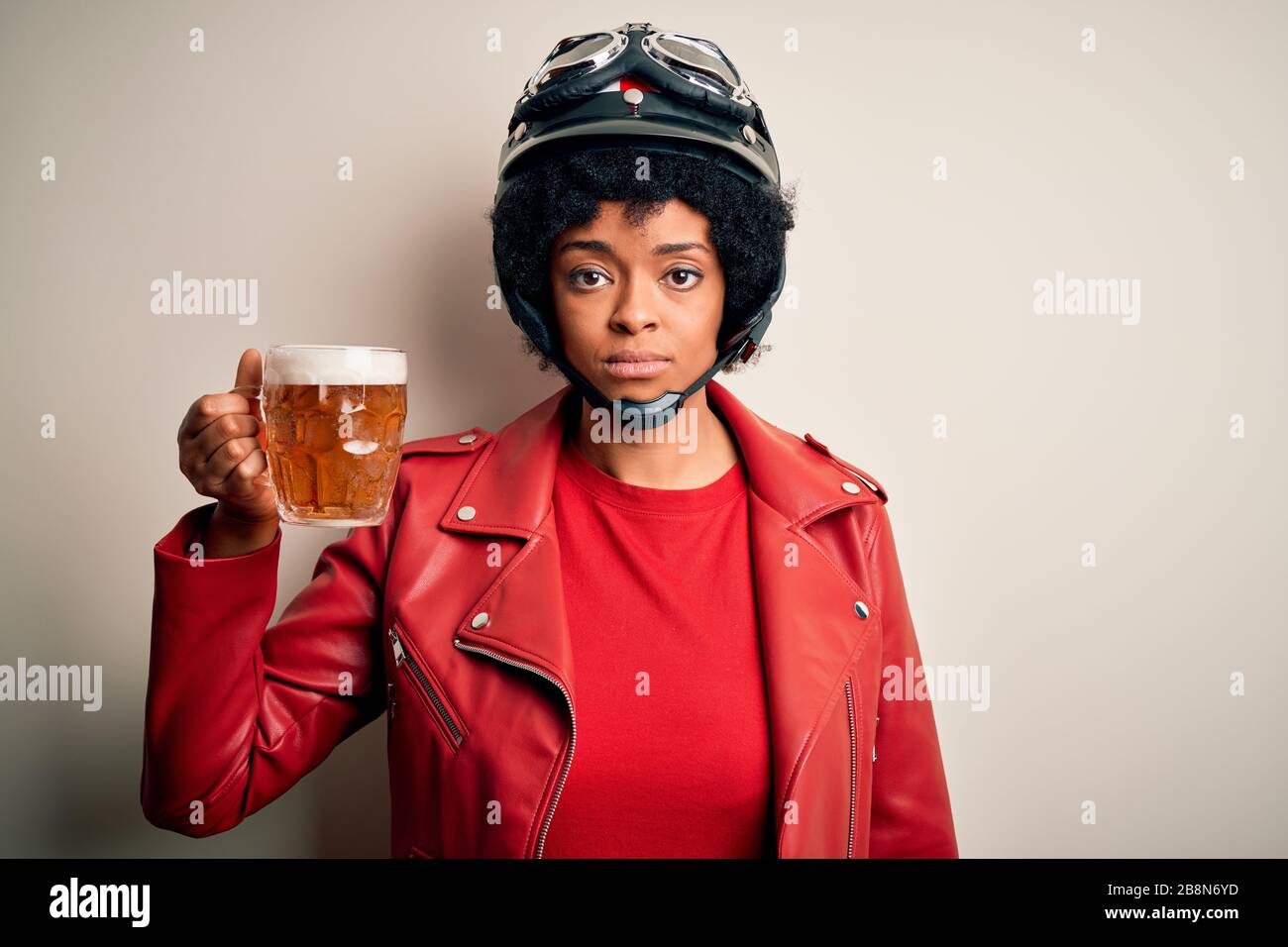 Young African American afro motorcyclist woman with curly hair drinking ...