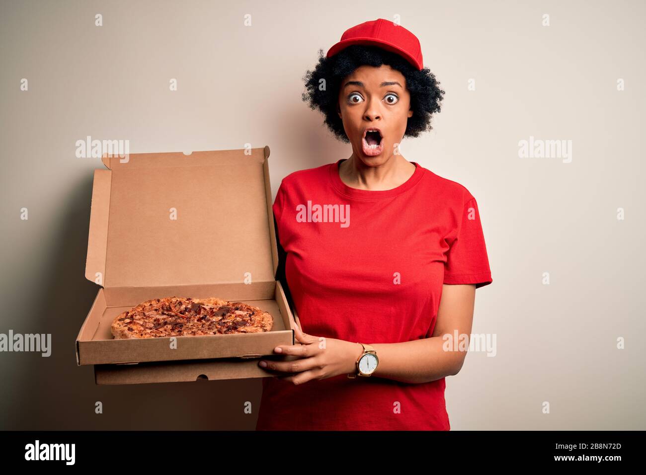 Young African American afro delivery woman with curly hair holding box ...
