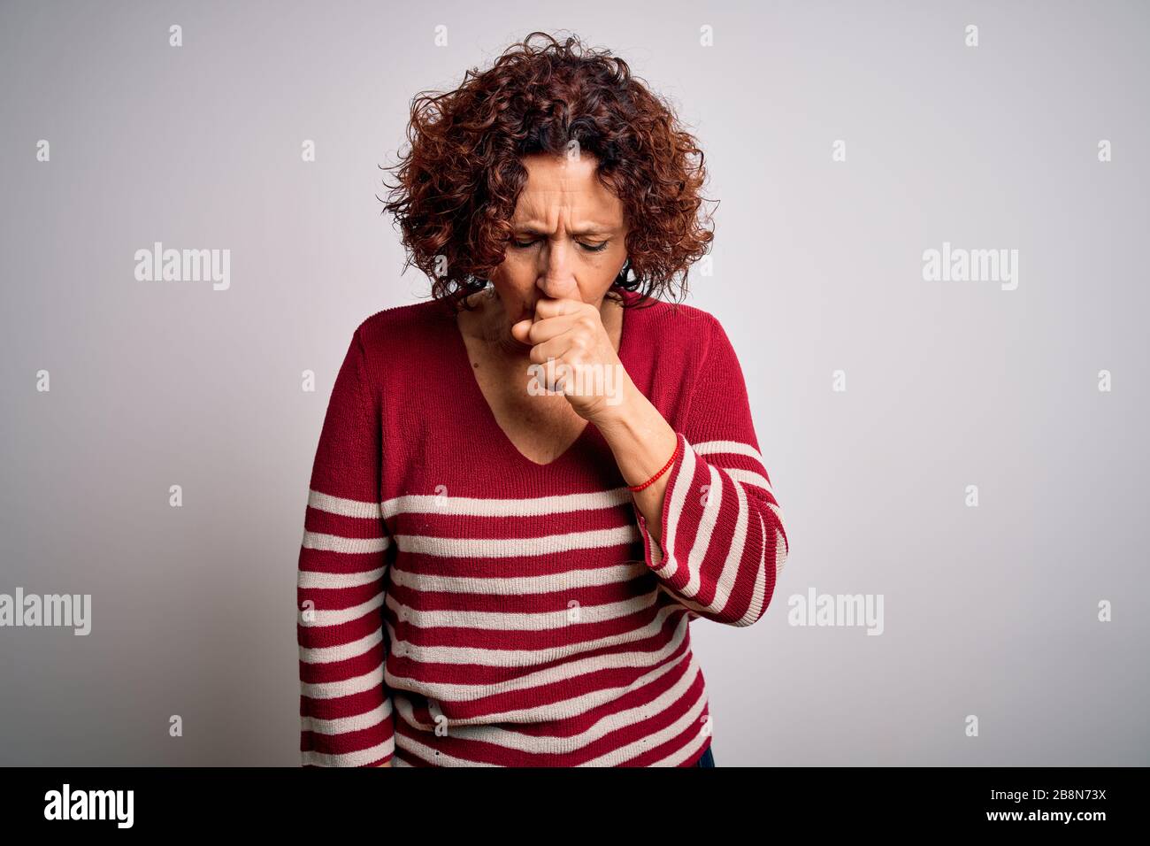 Middle age beautiful curly hair woman wearing casual striped sweater ...