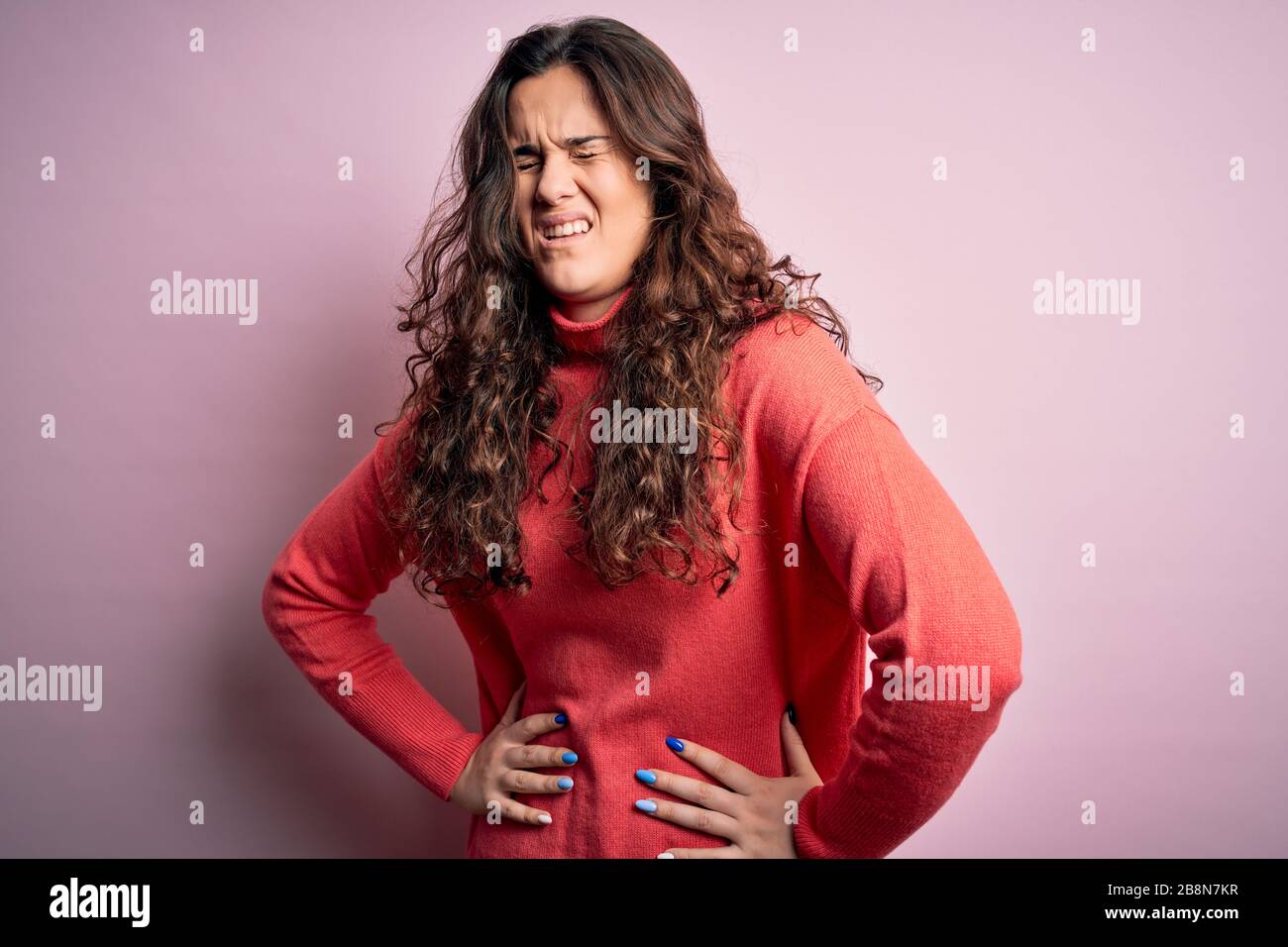 Young beautiful woman with curly hair wearing turtleneck sweater over ...