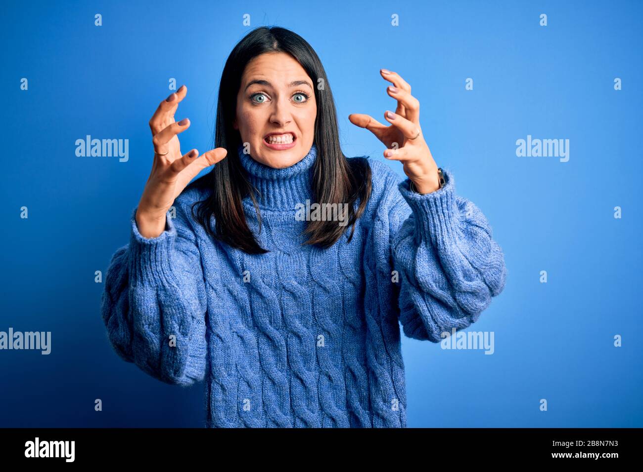 Young brunette woman with blue eyes wearing casual turtleneck sweater ...