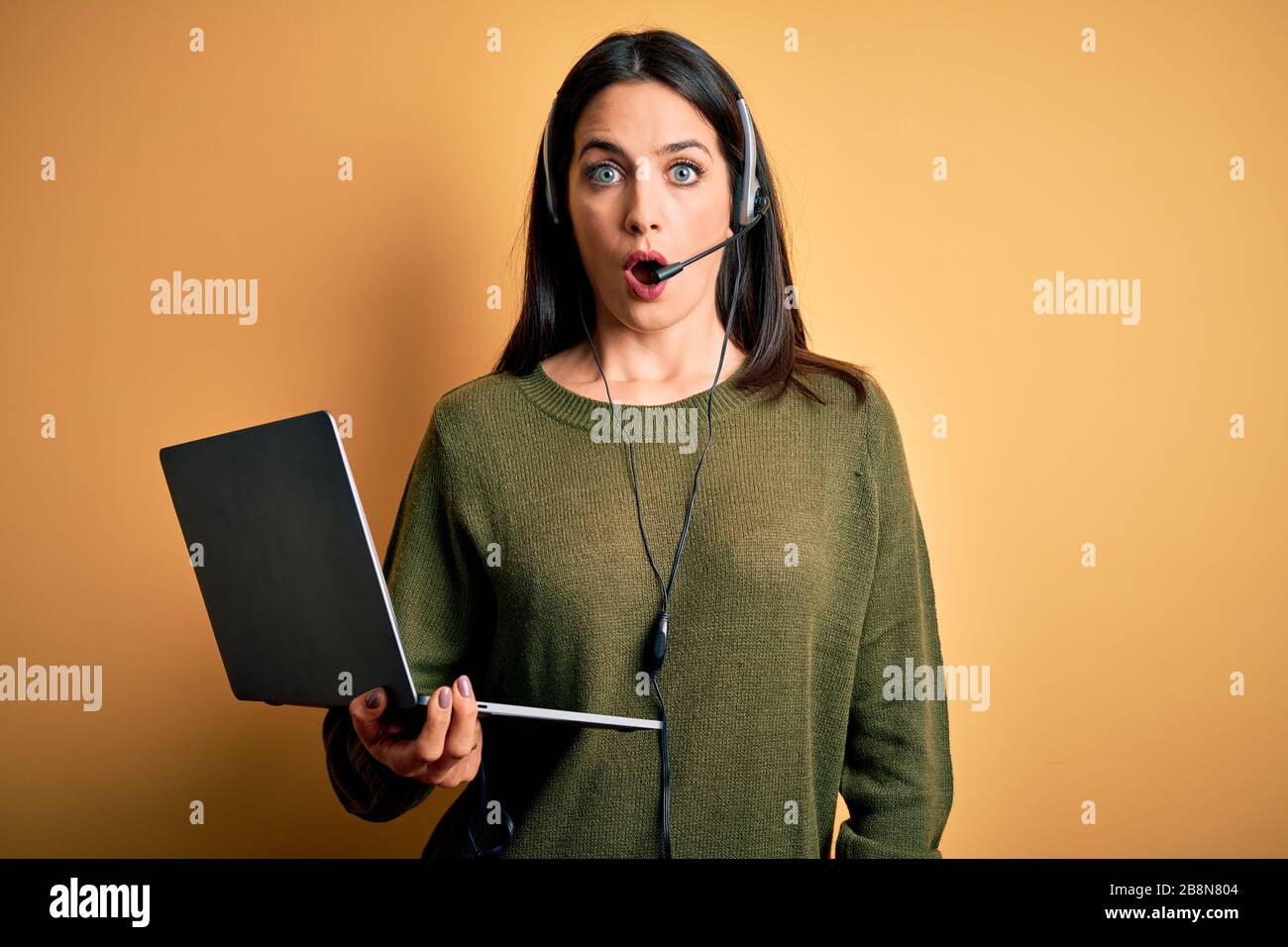 Young operator woman with blue eyes working on call center using ...