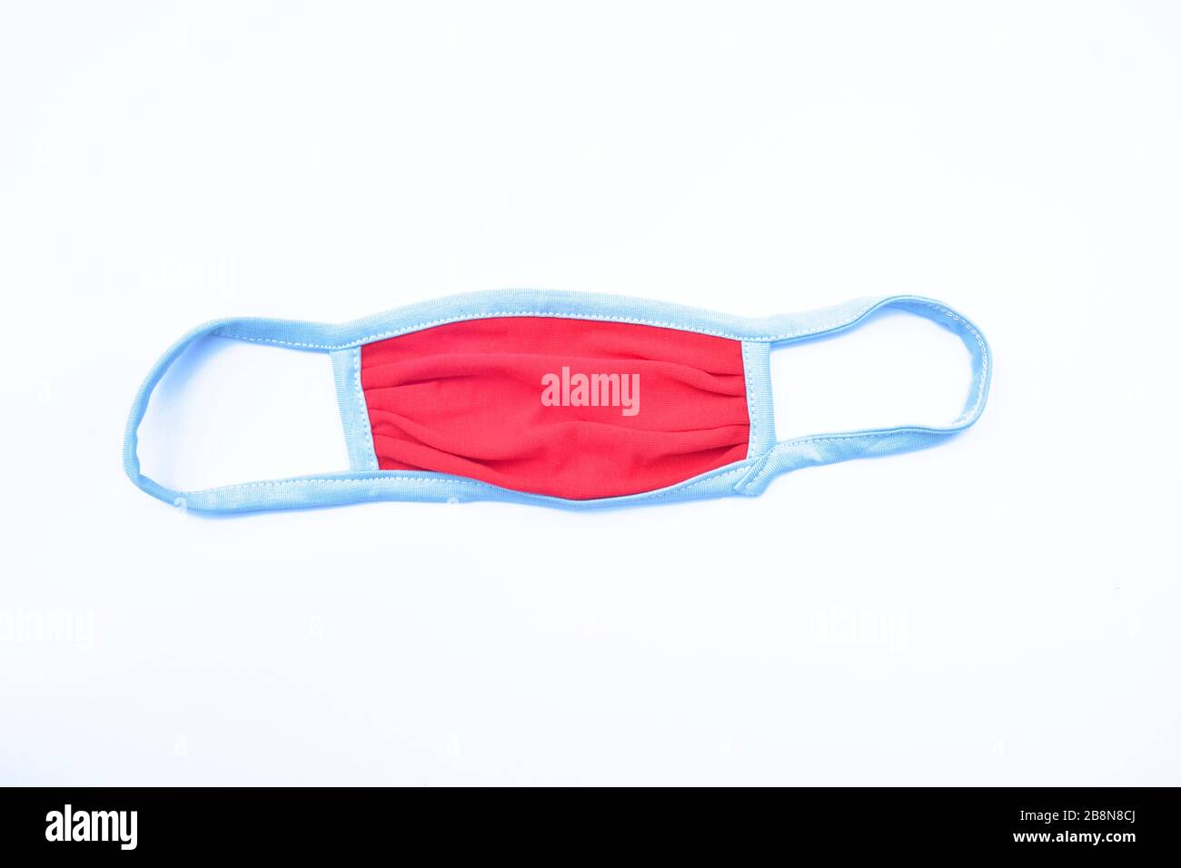 Red facial mask which is used is isolated on a light yellow paper ...