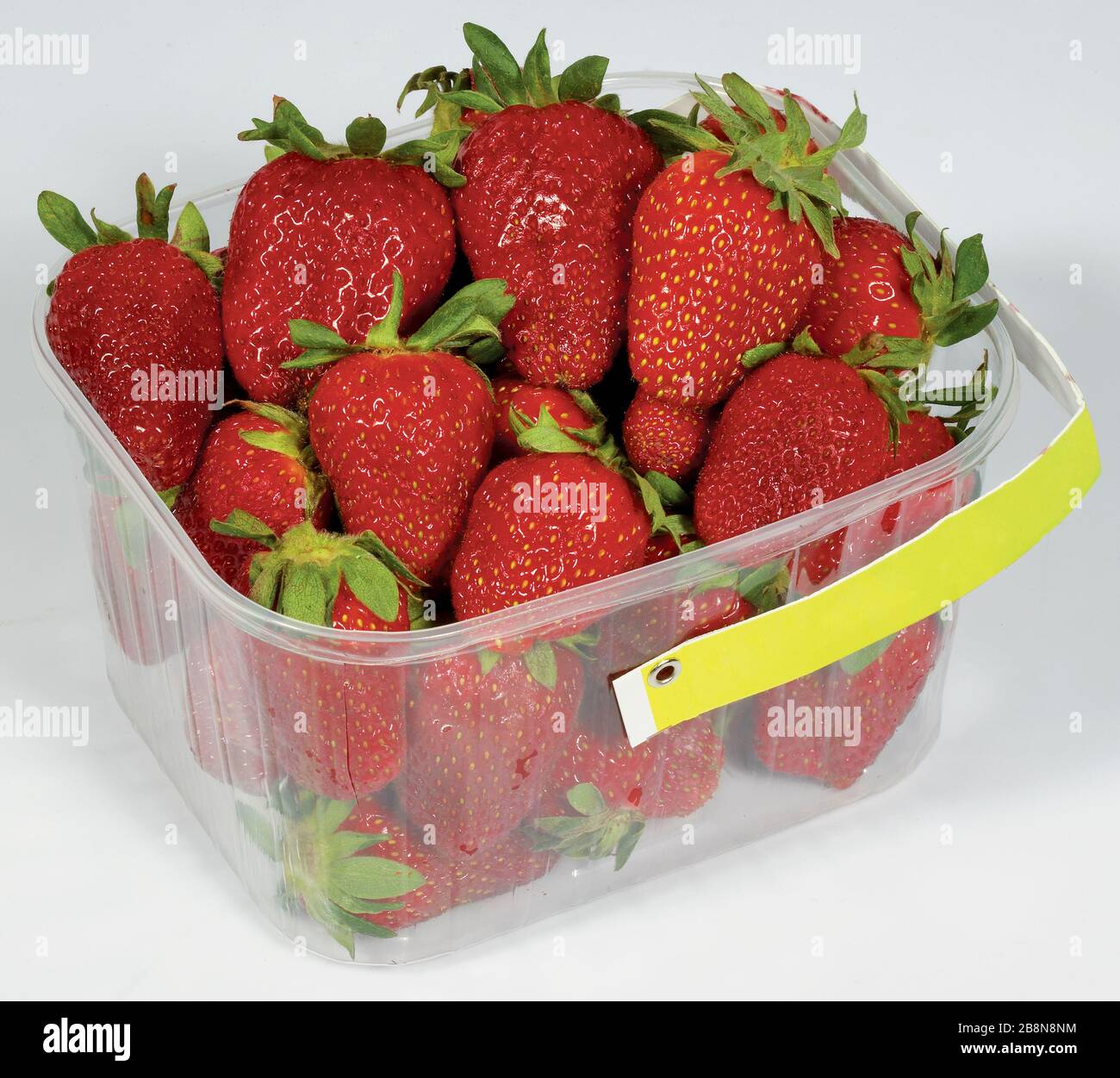 Strawberries in plastic container on a white background Stock Photo - Alamy