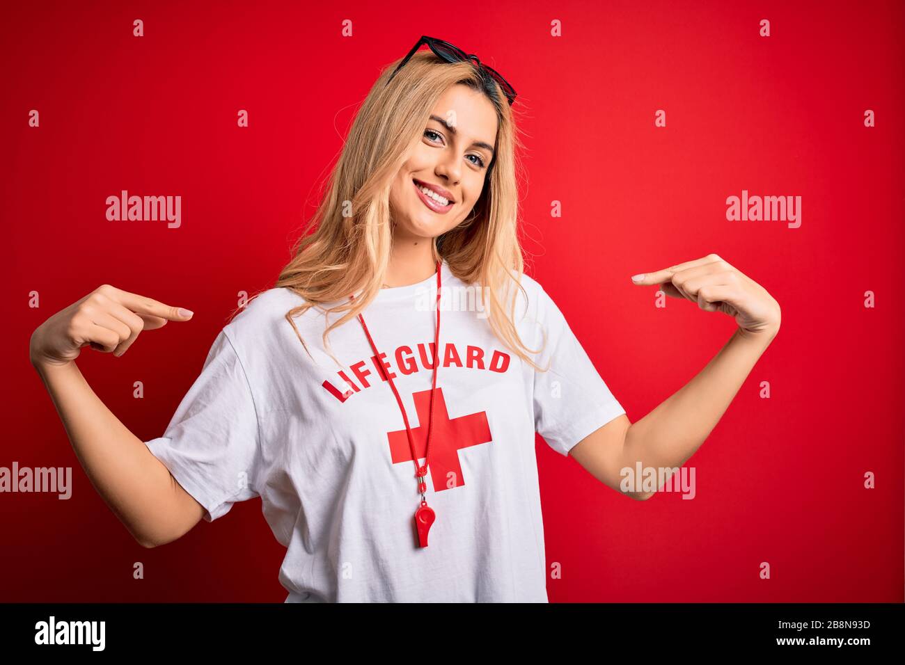 Young beautiful blonde lifeguard woman wearing t-shirt with red cross ...