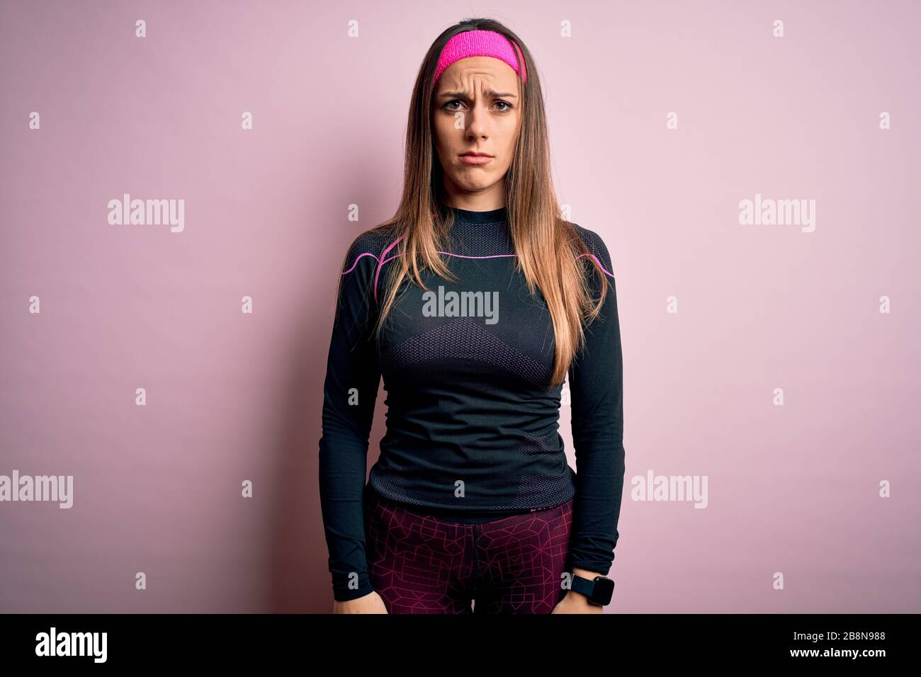 Young blonde fitness woman wearing sport workout clothes over isolated ...