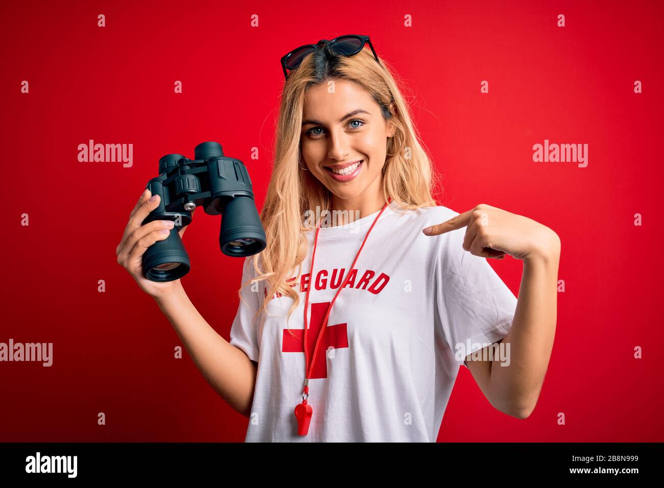 Young beautiful blonde lifeguard woman wearing t-shirt with red cross ...