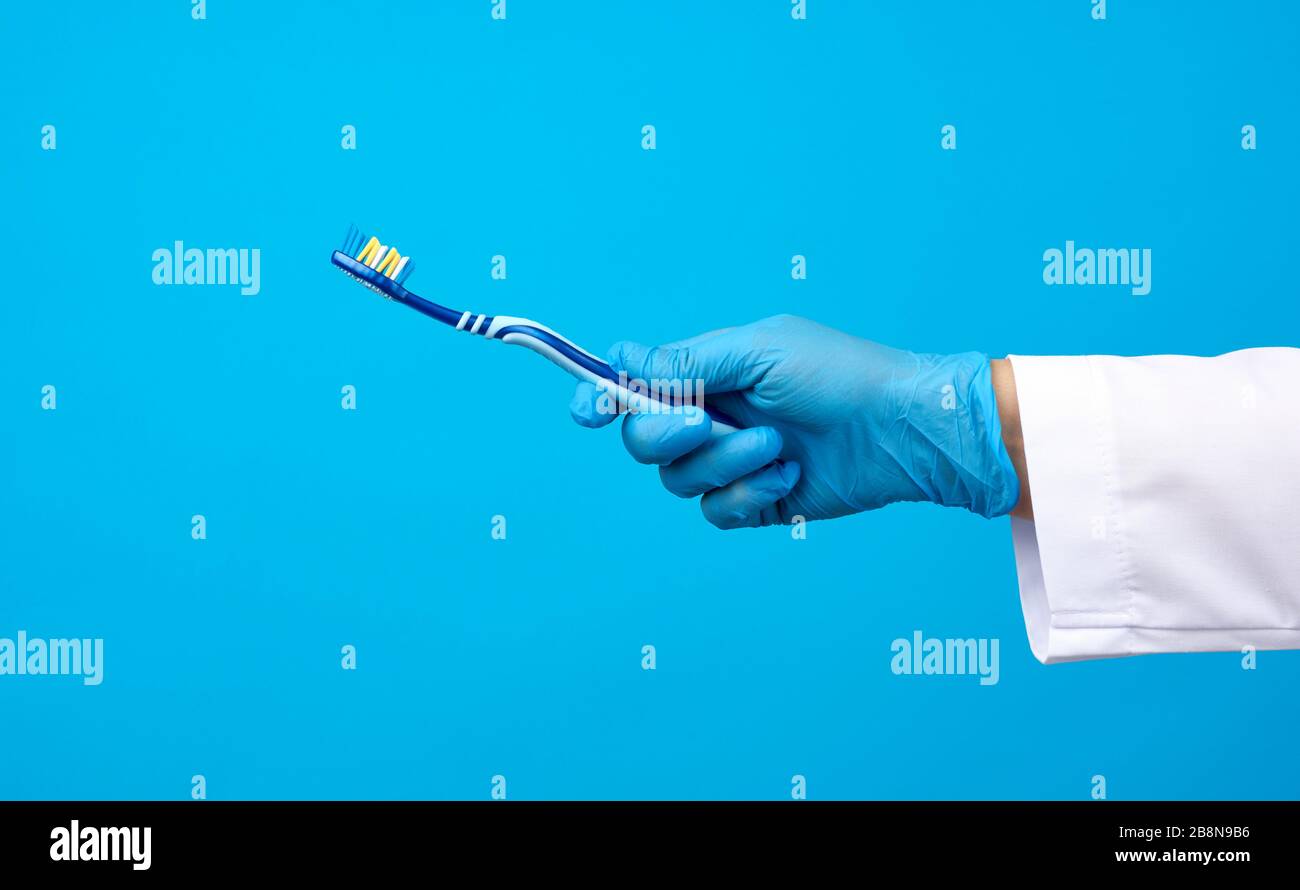 doctor therapist is dressed in a white robe uniform and blue sterile ...