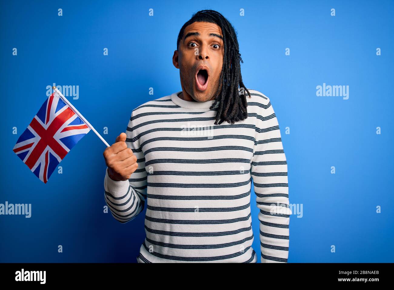 Young african american patriotic man with dreadlocks holding united ...