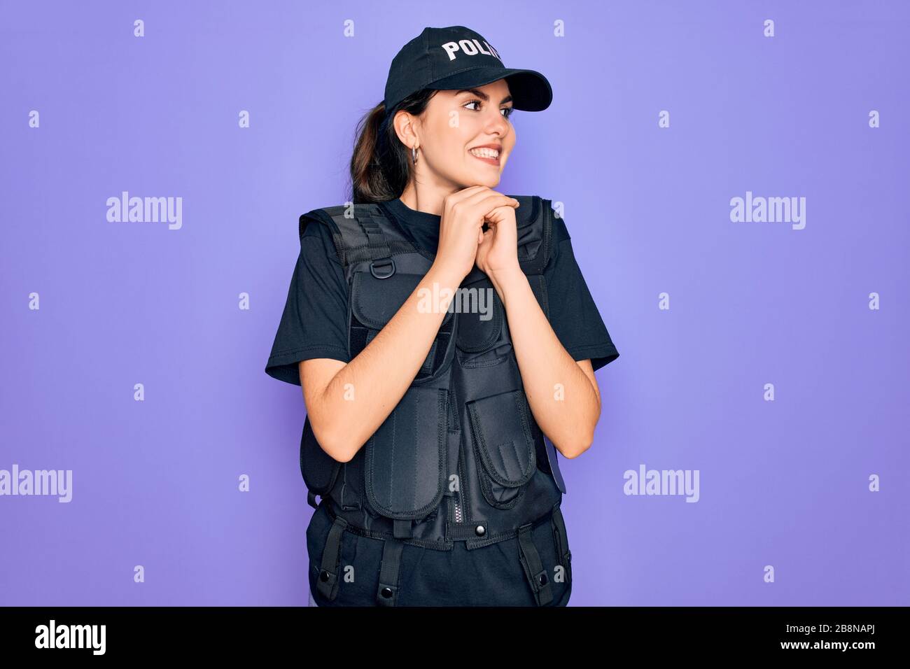 Young police woman wearing security bulletproof vest uniform over ...