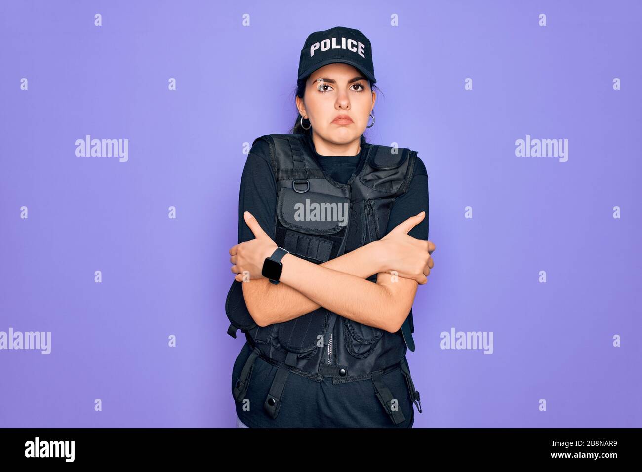 Young police woman wearing security bulletproof vest uniform over ...