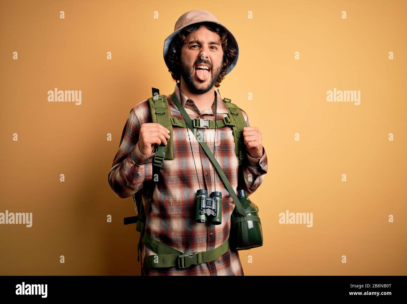 Young hiker man with curly hair and beard hiking wearing backpack and ...