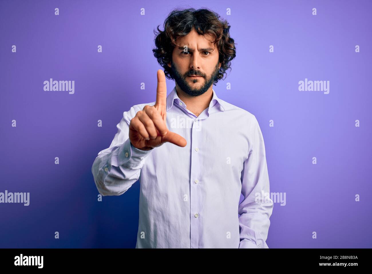 Young handsome business man with beard wearing shirt standing over ...
