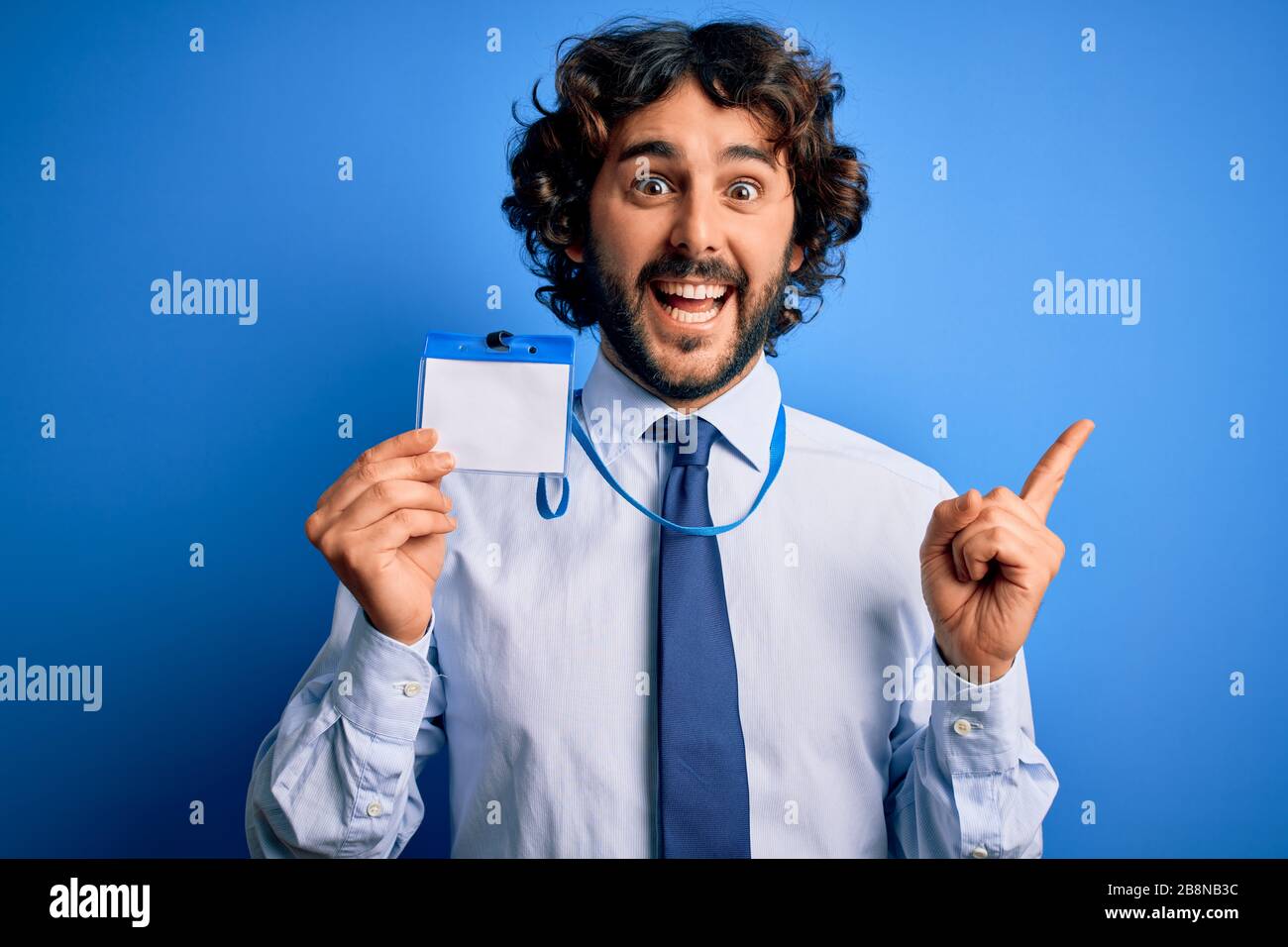 Young handsome business man with beard holding id card identification ...