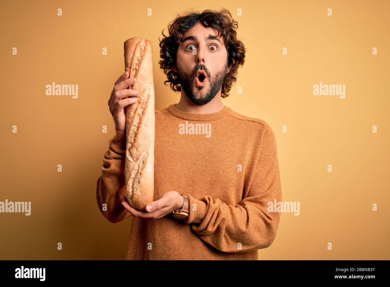 Young handsome man with curly hair and beard holding homemade healthy ...