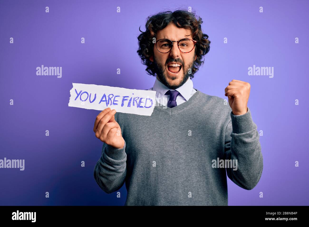 Handsome business man with beard holding you are fired message over ...