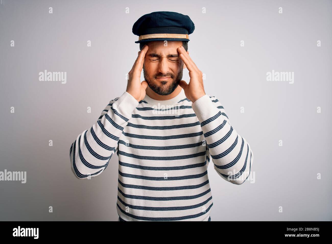 Young handsome sailor man with beard wearing navy striped uniform and ...