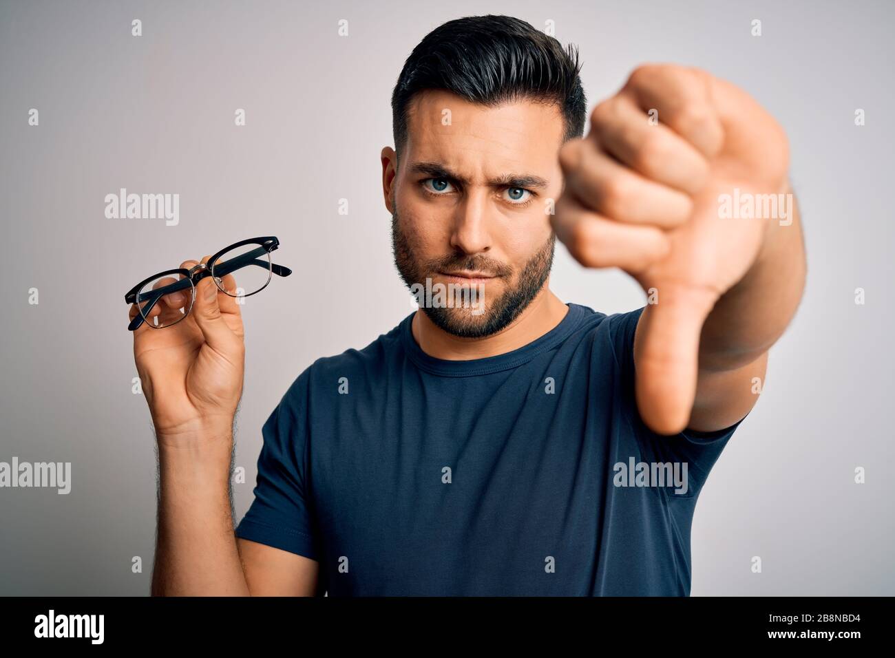 Young handsome man holding correction eye glasses over isolated ...