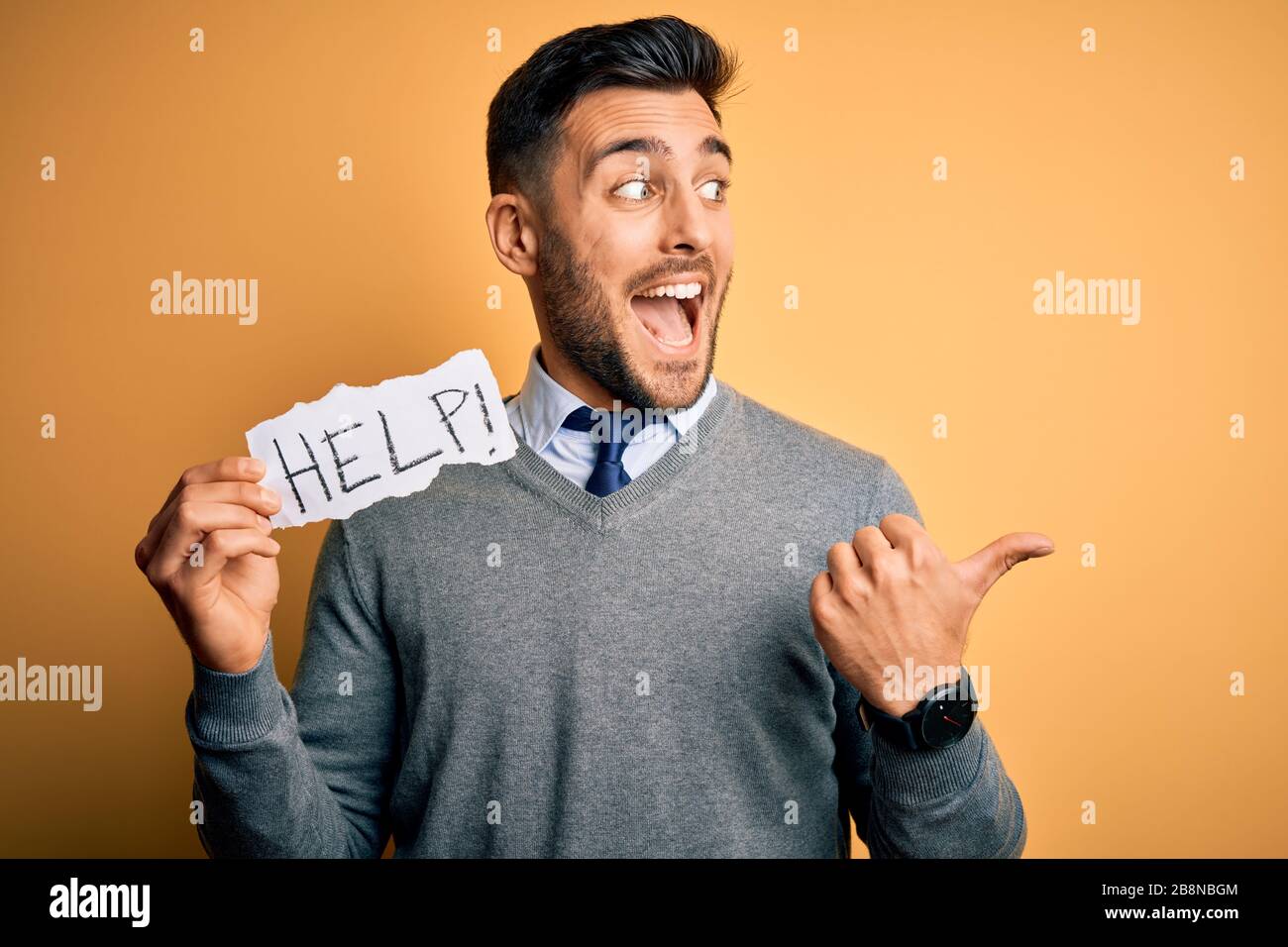 Young overworked business man asking for help holding paper over yellow ...