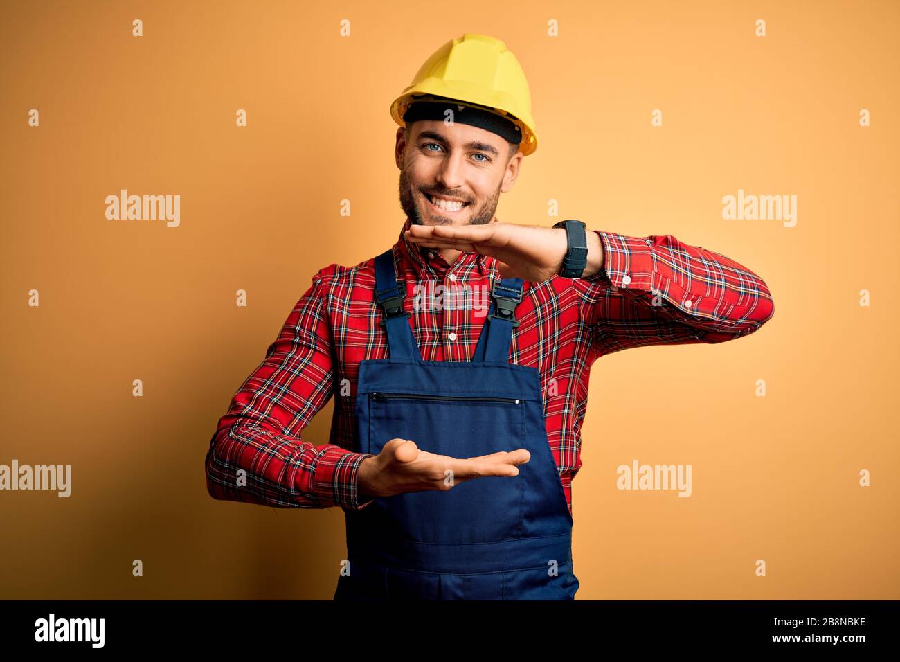 Young builder man wearing construction uniform and safety helmet over ...