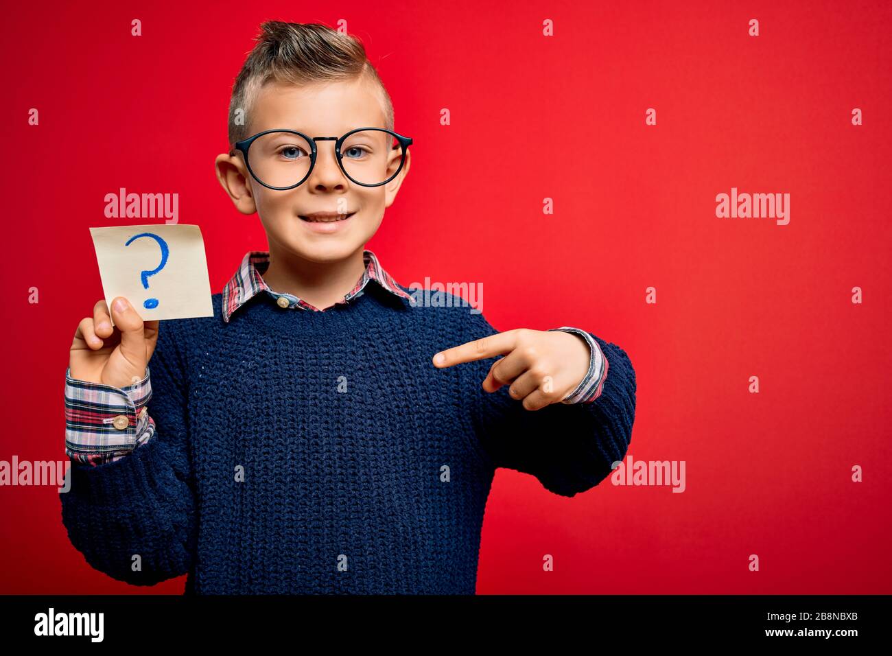 Young little caucasian kid wearing glasses holding paper note with ...
