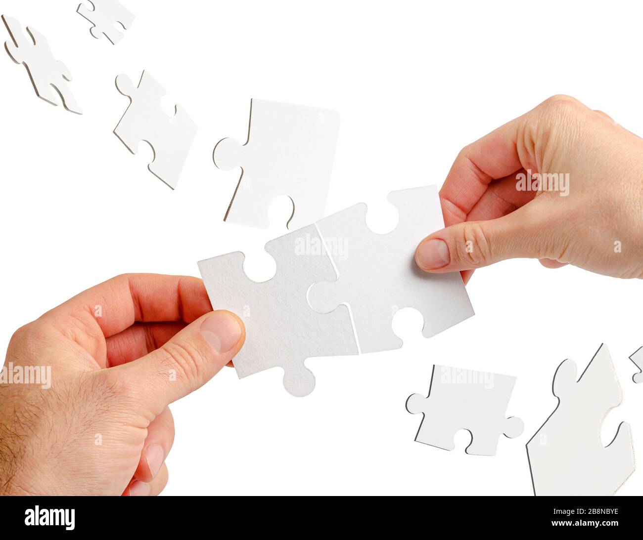 Couple of hands holding jigsaw puzzle isolated on white. Teamwork and ...