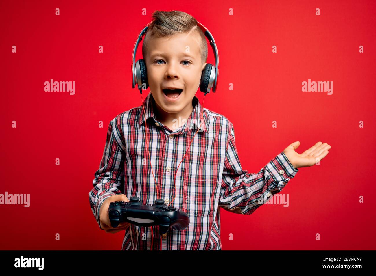 Young little caucasian gamer kid playing video games using gamepad ...