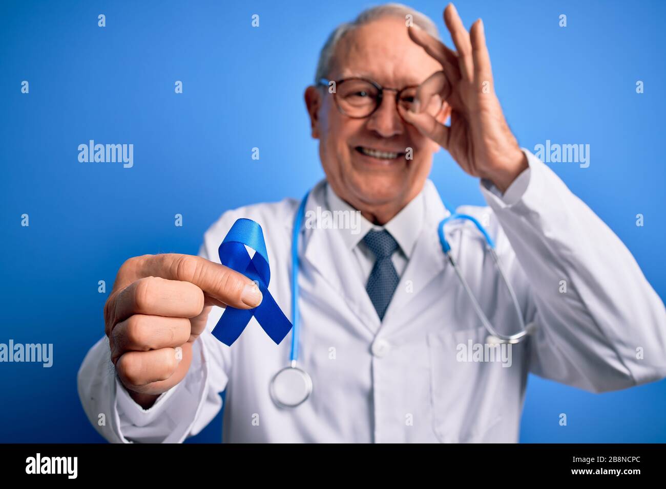 Grey haired senior doctor man holding colon cancer awareness blue ...