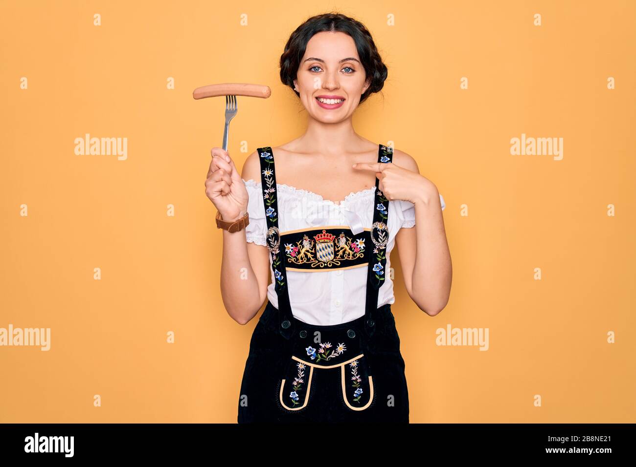 Young german woman with blue eyes wearing octoberfest dress holding ...