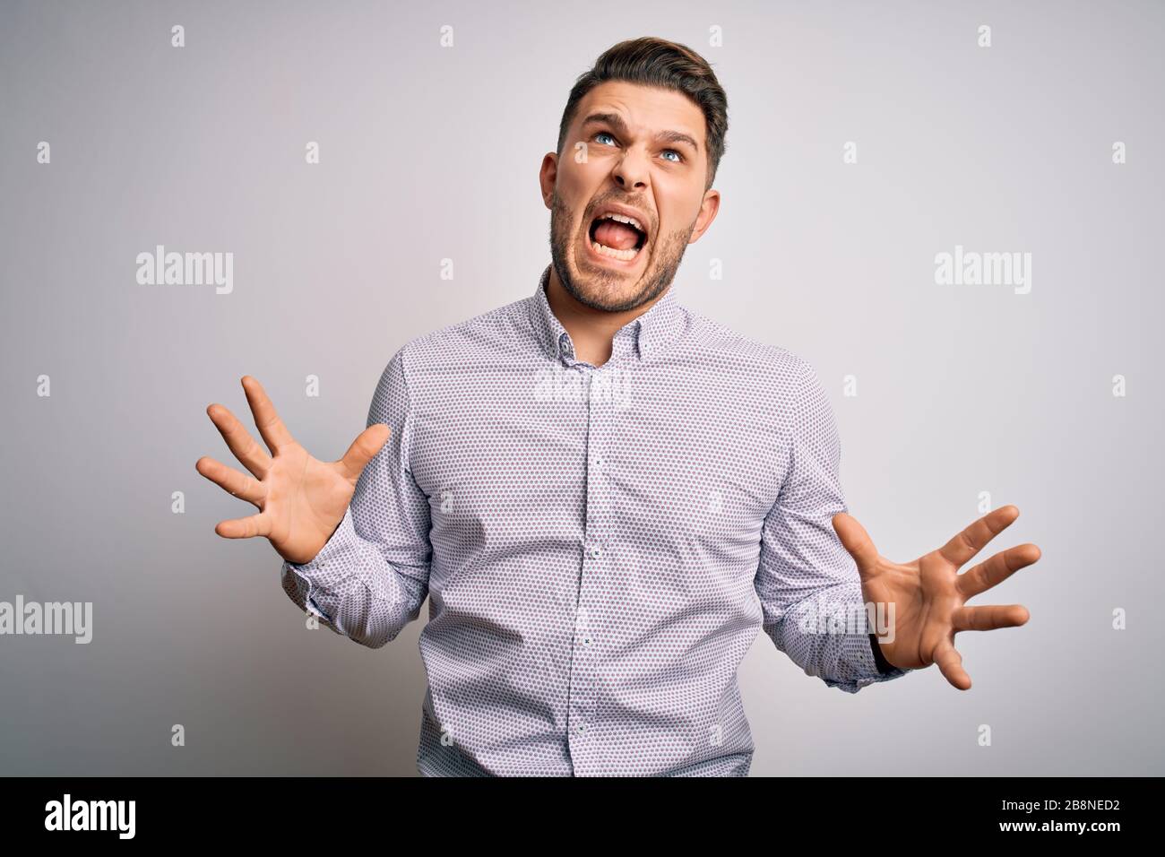 Young business man with blue eyes standing over isolated background ...