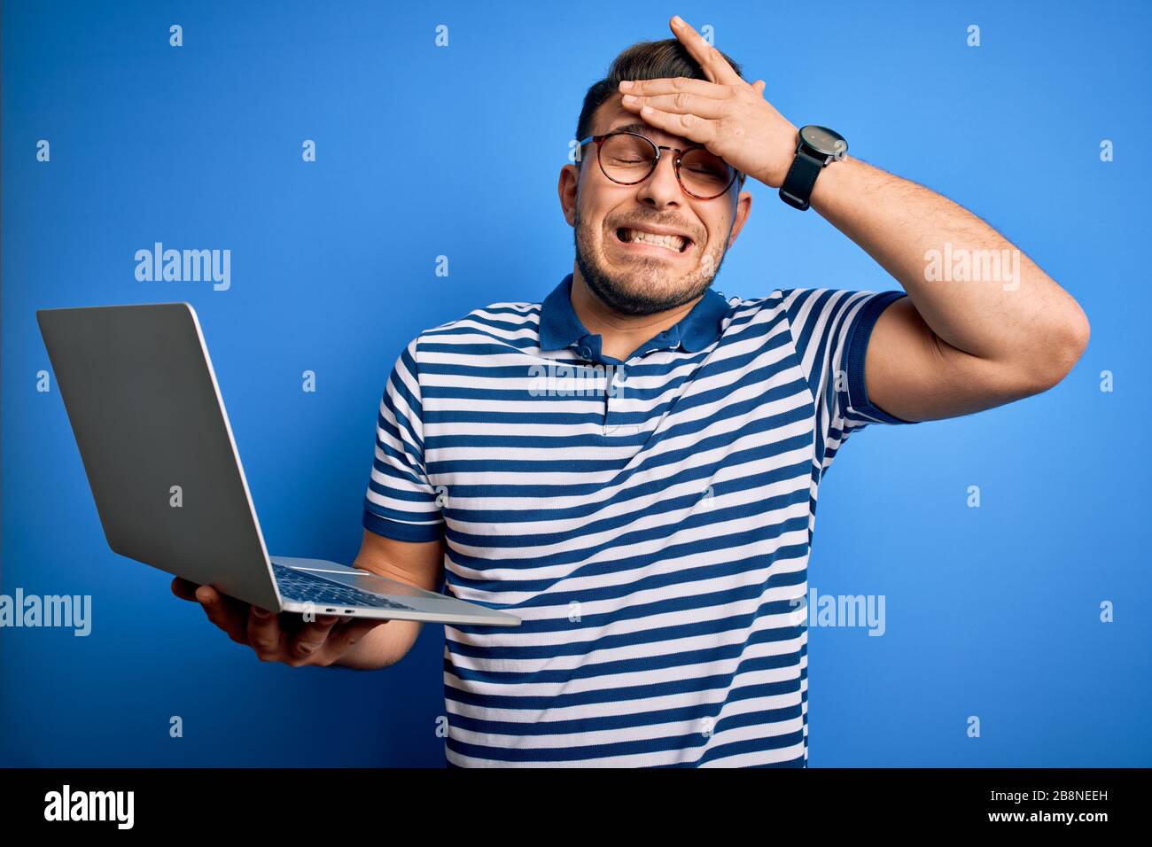 Young business man with blue eyes wearing glasses working using ...