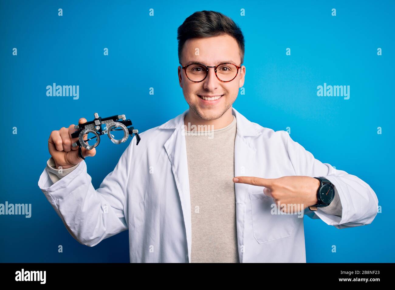 Young handsome professional optic man holding optometrical glasses over ...