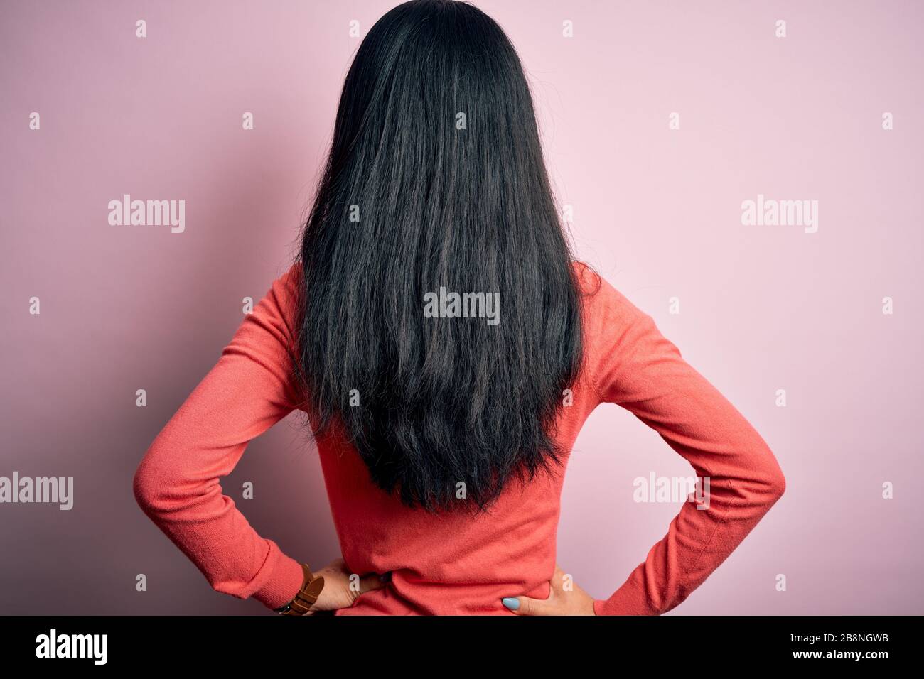 Young beautiful chinese woman wearing casual sweater over isolated pink ...