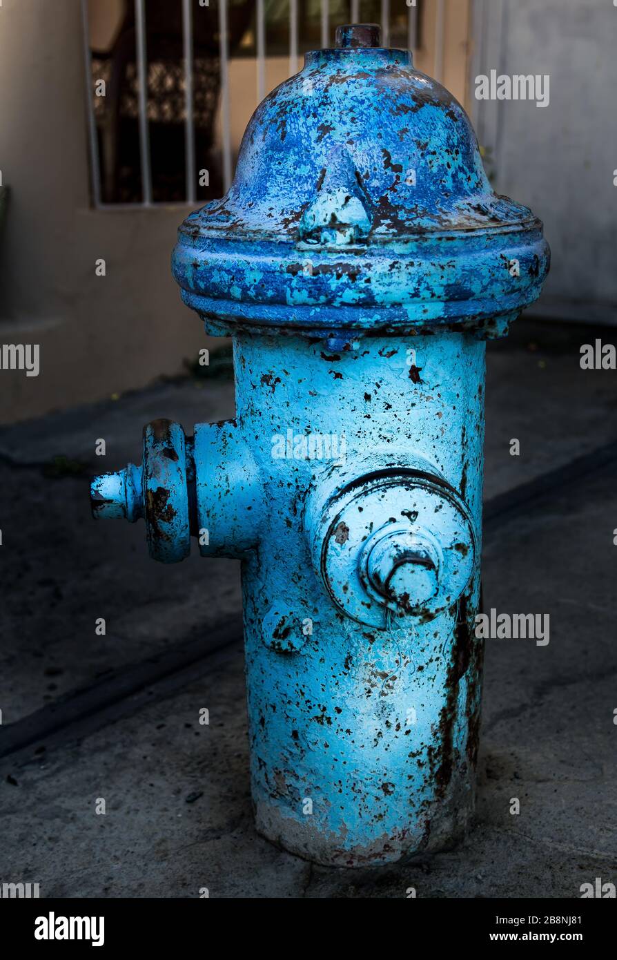 dramatic blue and aqua rusted old fire hydrant with paint peeling off ...