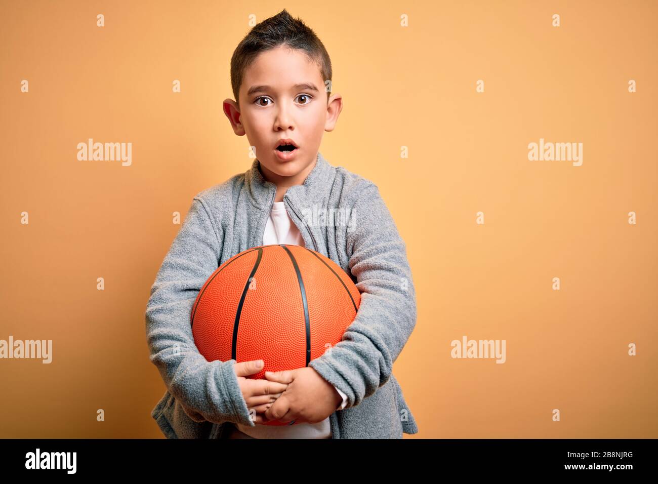 Young little boy kid playing with basketball game ball over isolated ...