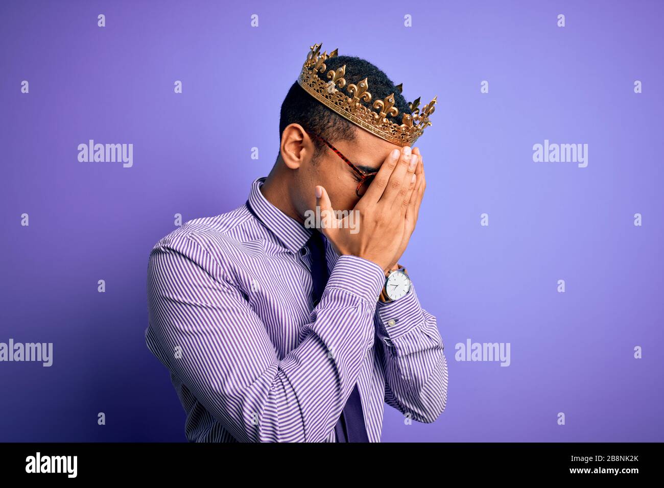 Young handsome african american man wearing golden crown of king over ...