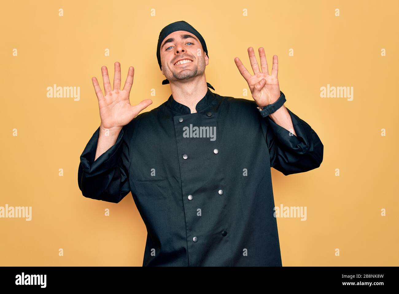 Young handsome cooker man with blue eyes wearing uniform and hat over ...