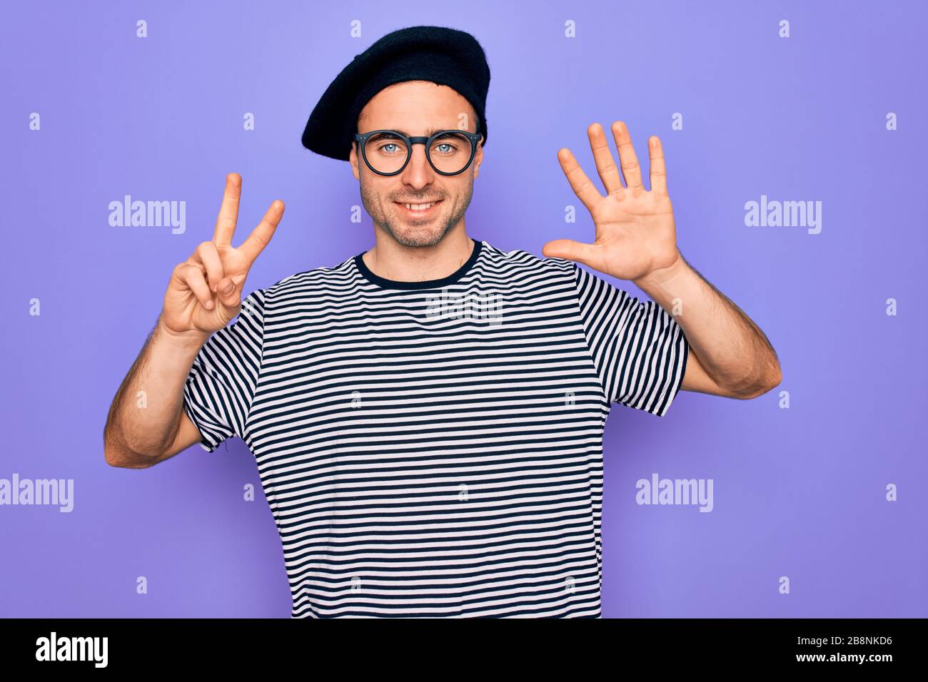 Handsome man with blue eyes wearing striped t-shirt and french beret ...