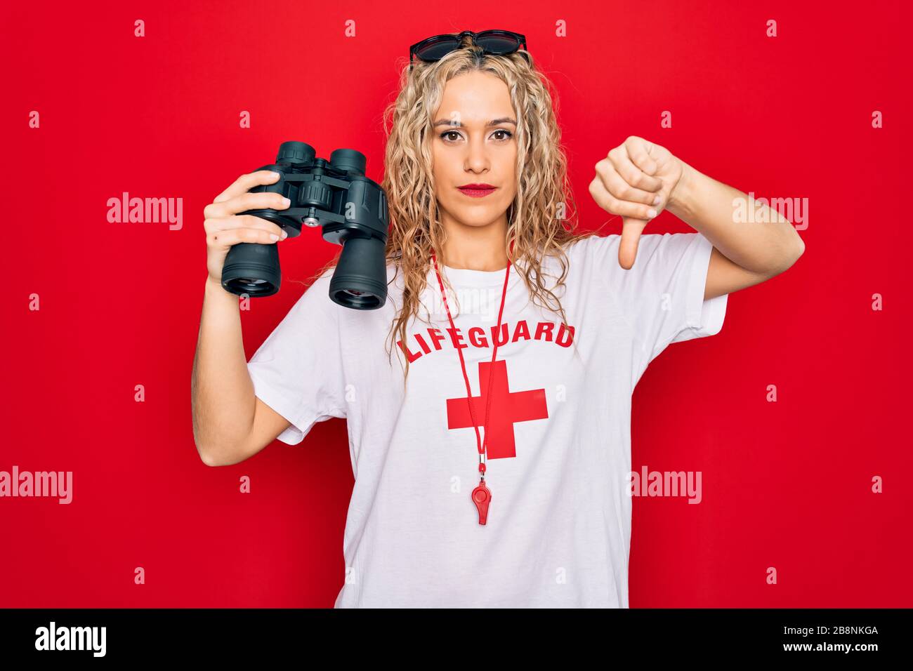 Beautiful blonde lifeguard woman wearing t-shirt with red cross and ...