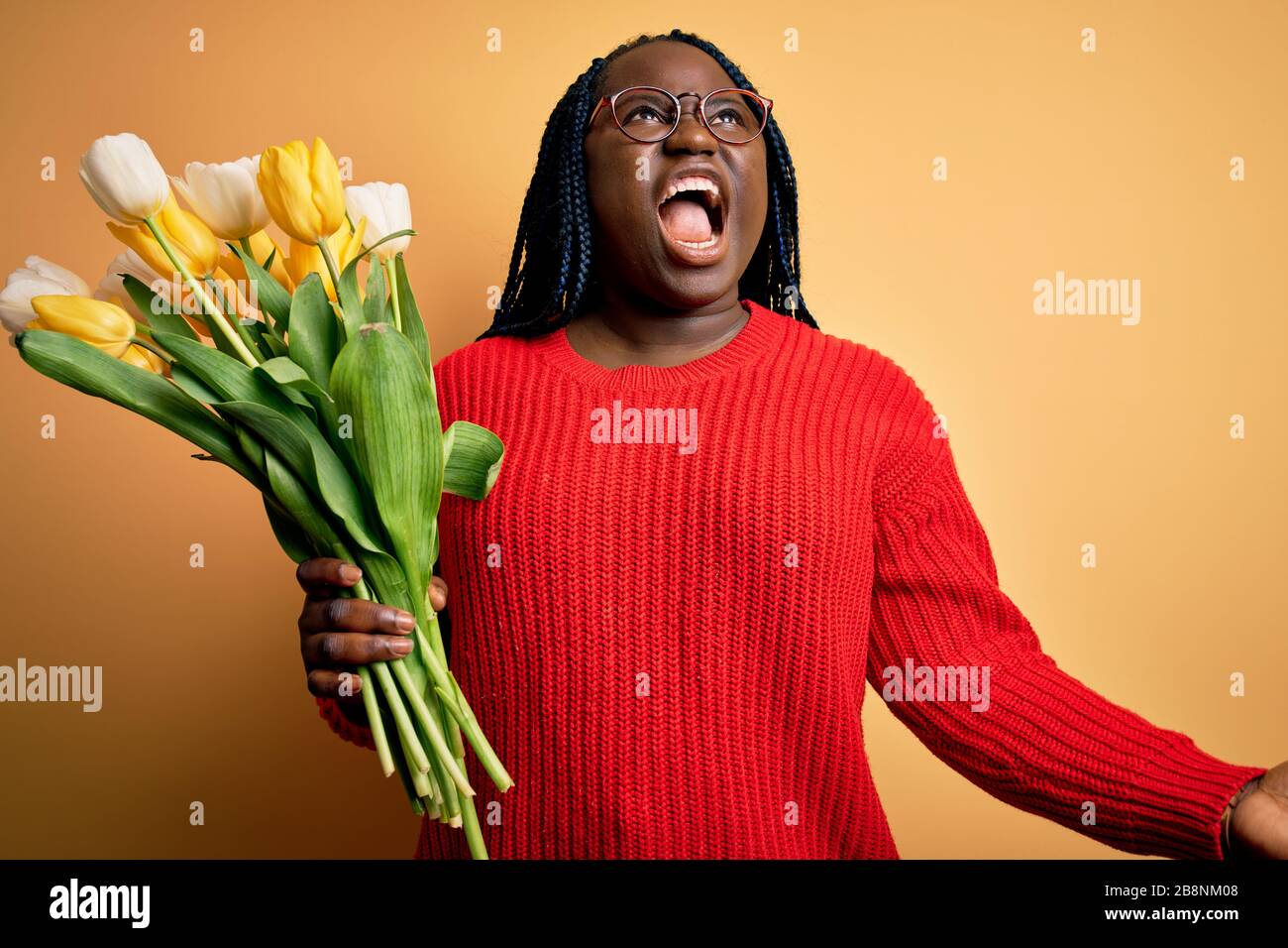 Young african american plus size woman with braids holding bouquet of ...