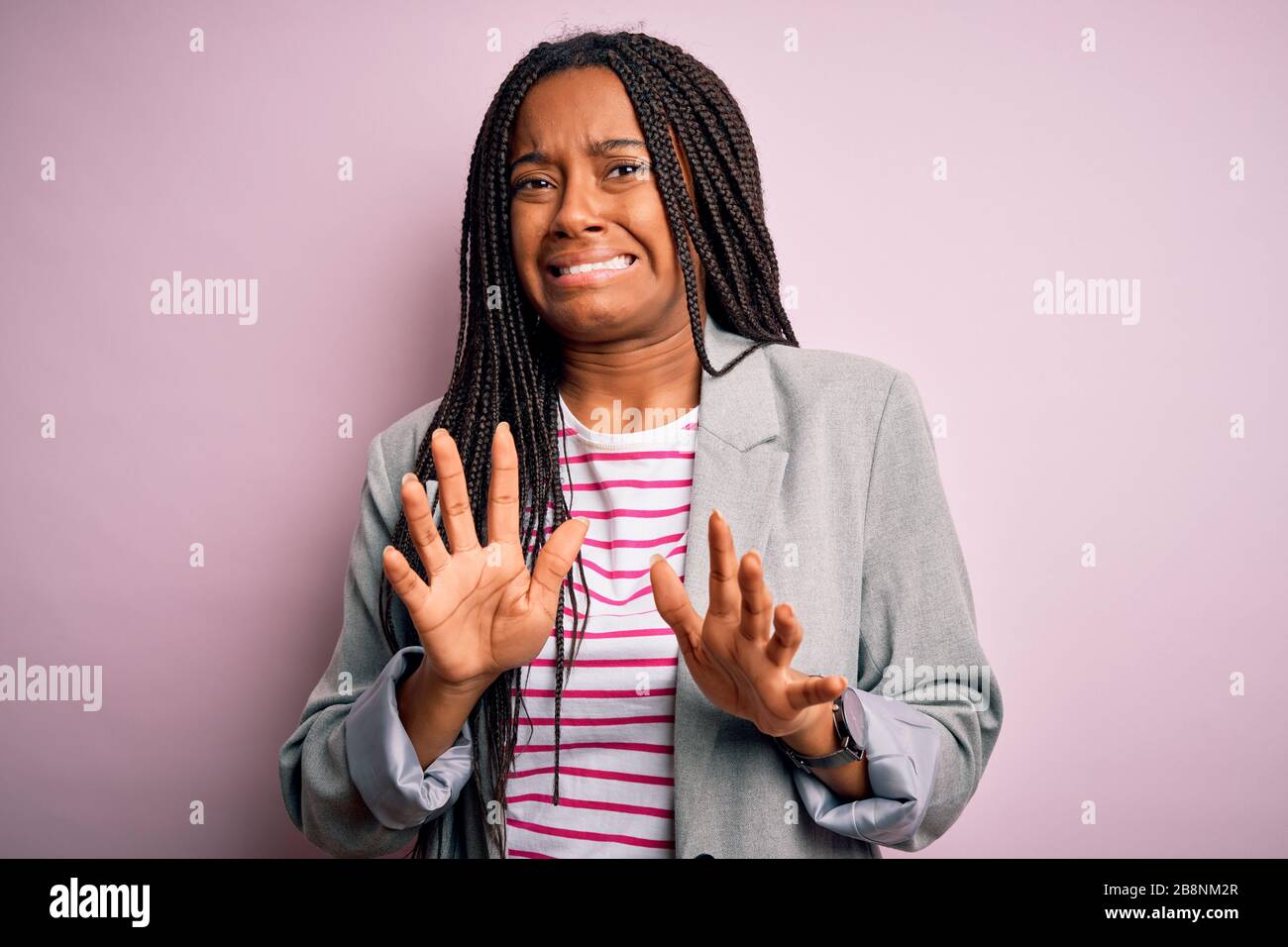Young african american business woman standing over pink isolated ...