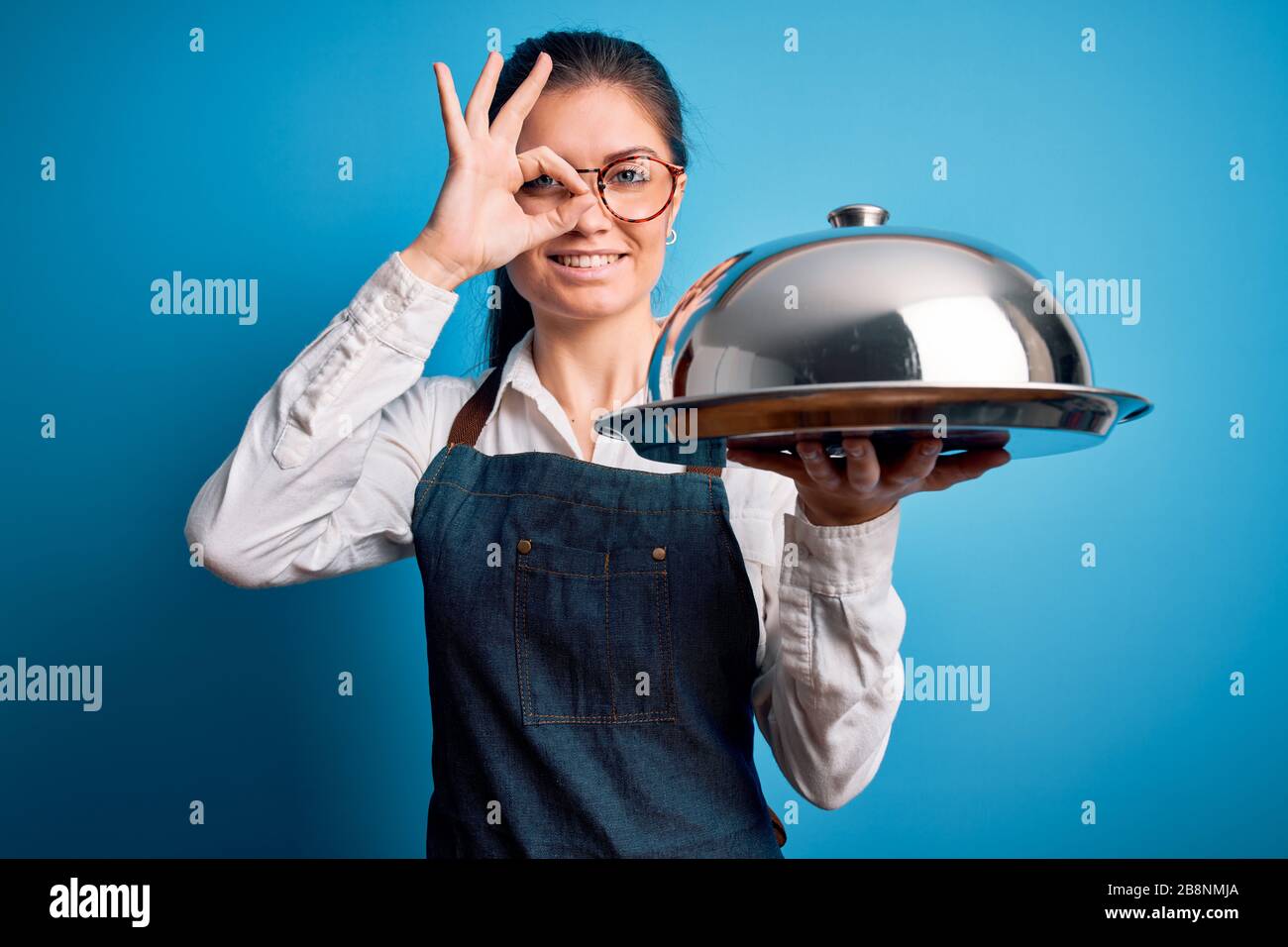 Young beautiful waitress woman with blue eyes holding tray with dome ...