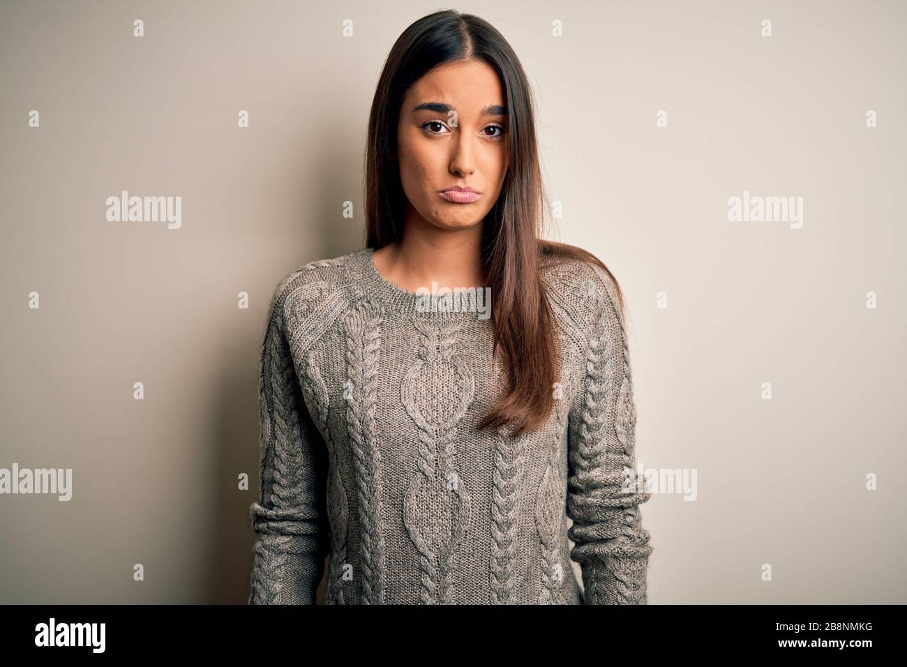 Young beautiful brunette woman wearing casual sweater over isolated ...