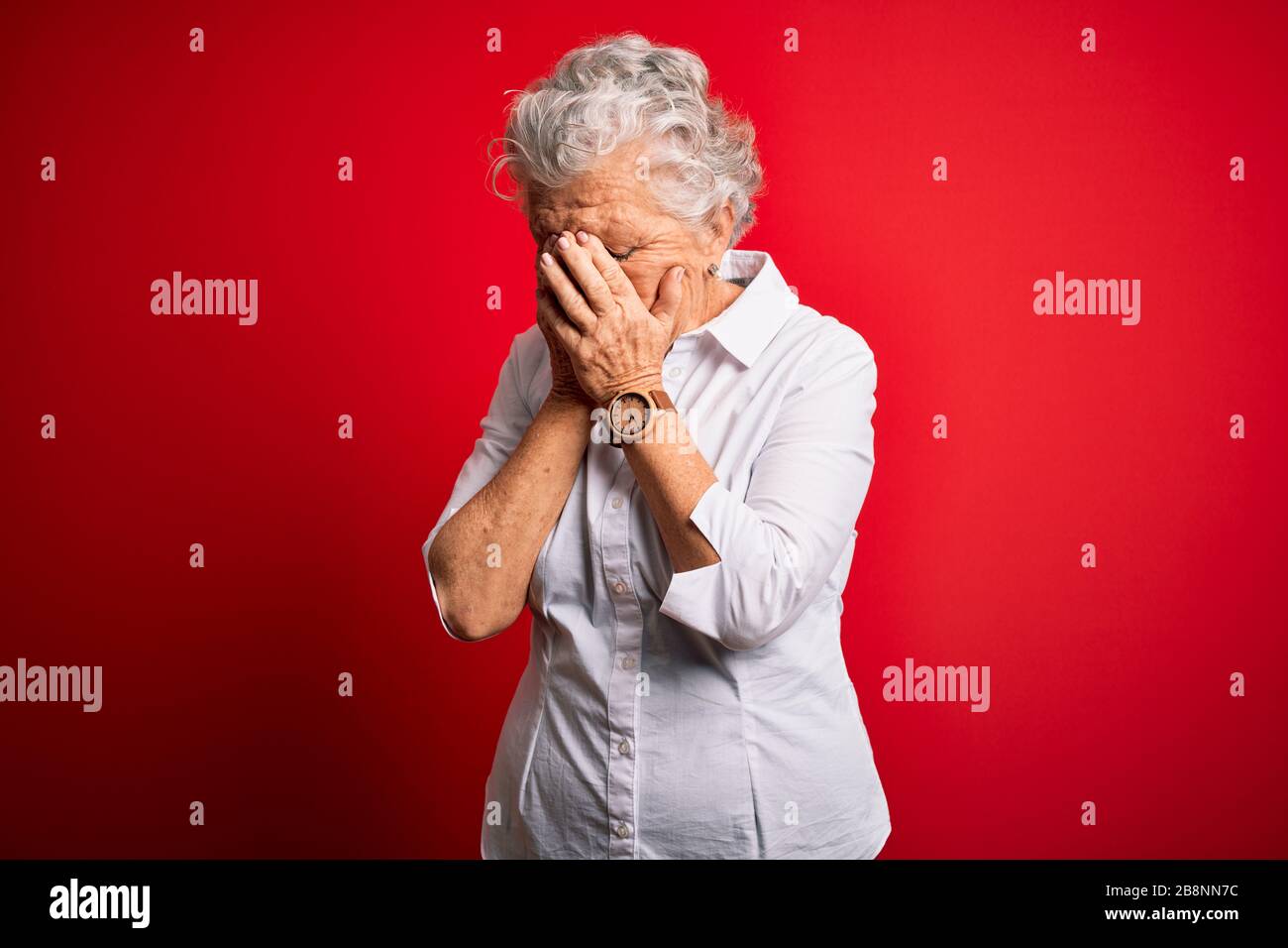 Senior beautiful woman wearing elegant shirt standing over isolated red ...