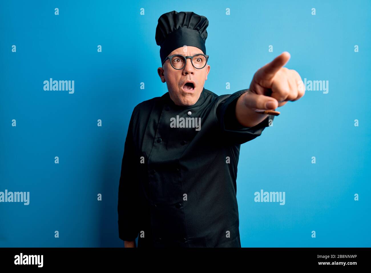 Middle age handsome grey-haired chef man wearing cooker uniform and hat ...